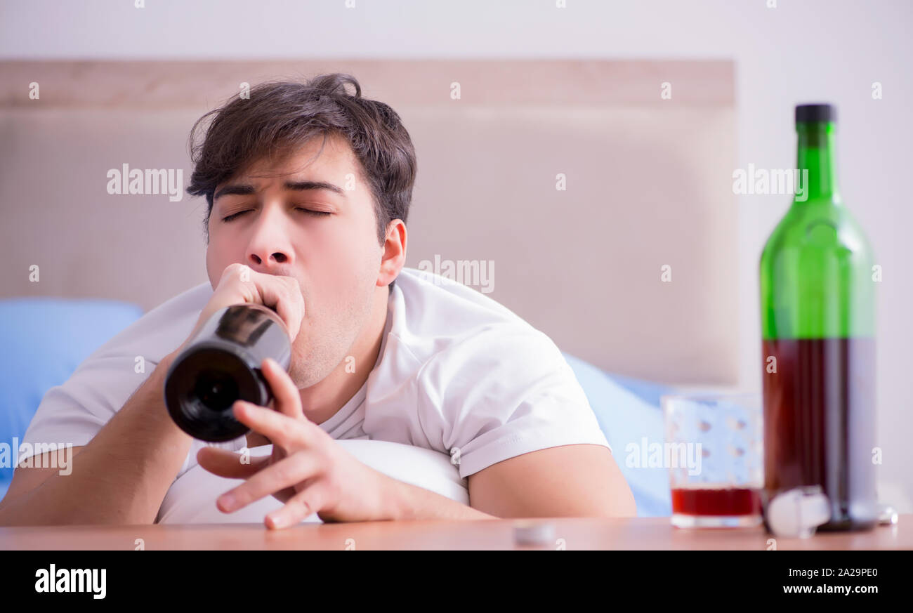 The man alcoholic drinking in bed going through break up depression Stock Photo - Alamy