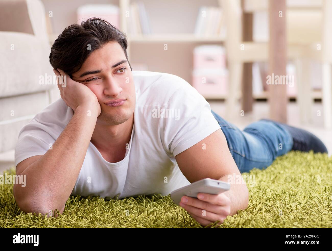 Man watching tv at home on floor Stock Photo - Alamy