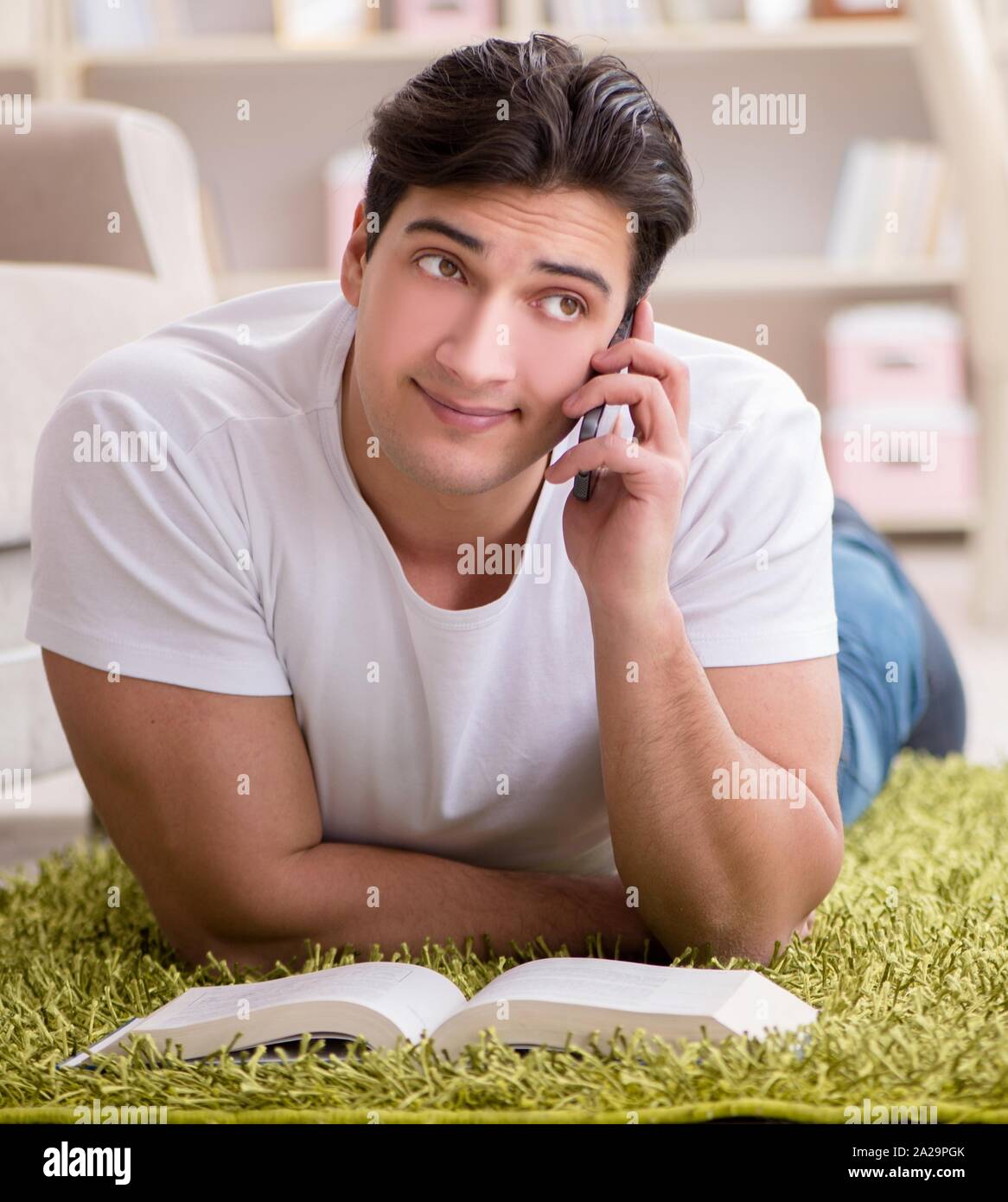 The man reading book at home on floor Stock Photo - Alamy