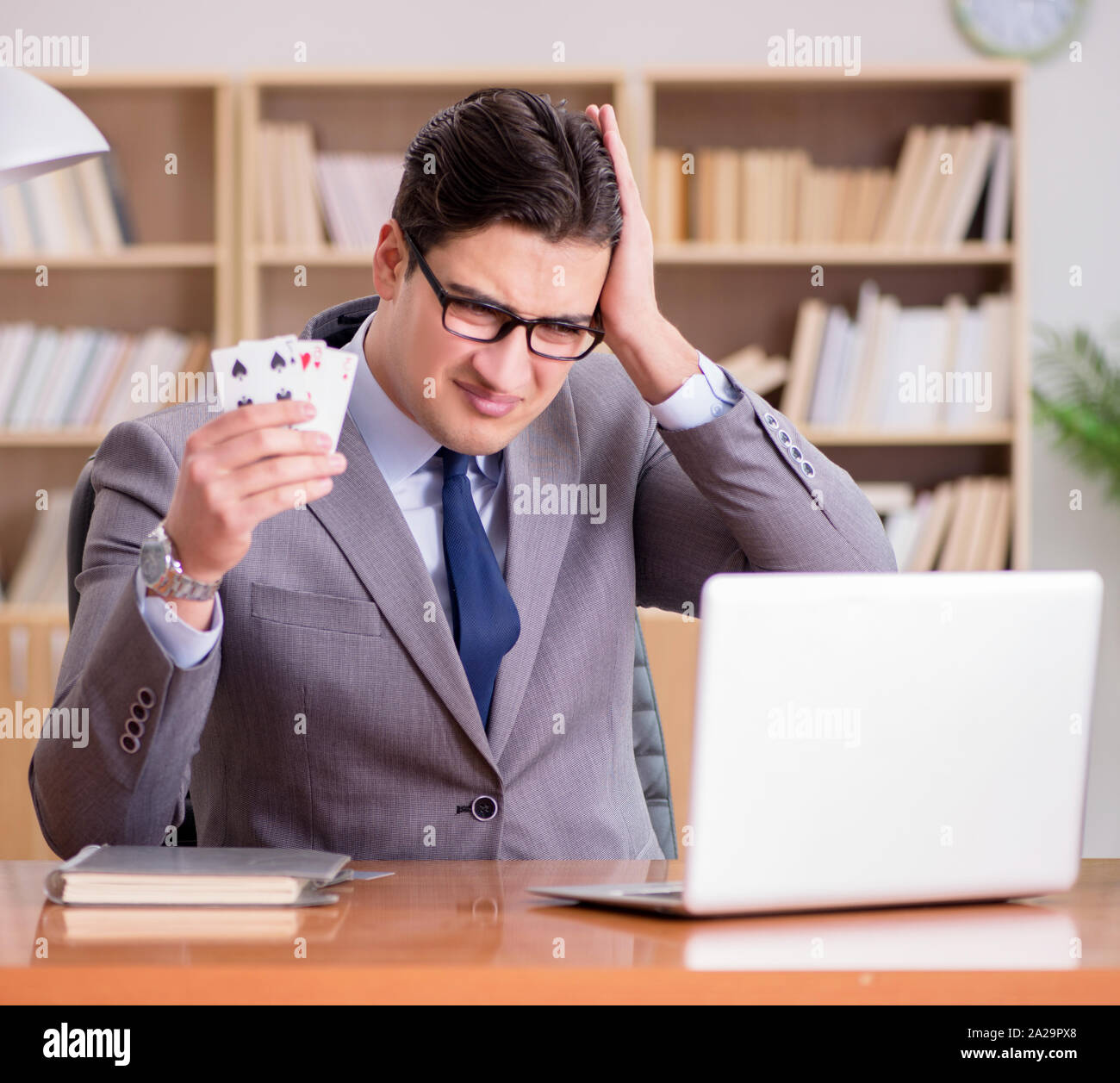 The businessman gambling playing cards at work Stock Photo - Alamy