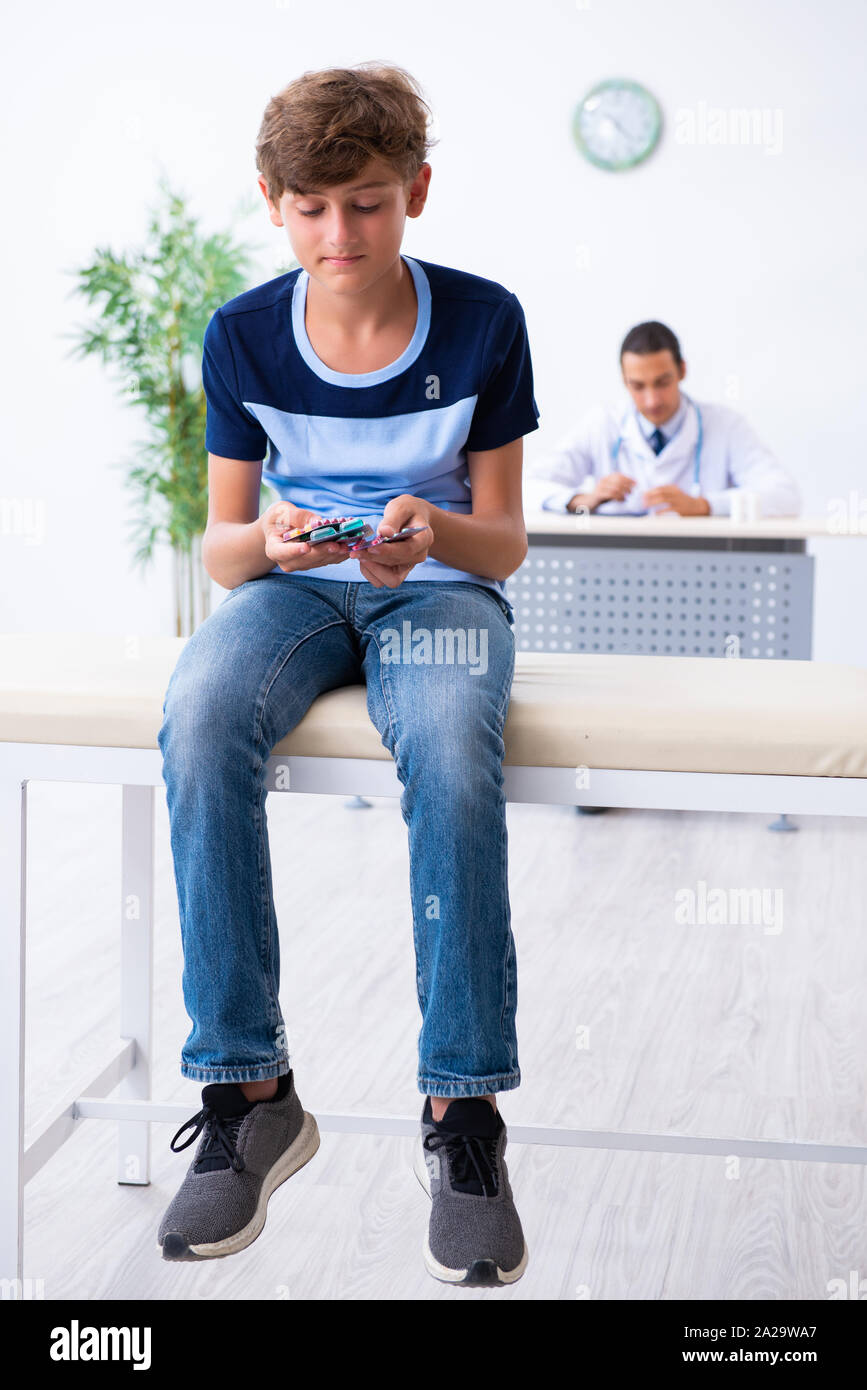 The young male doctor examining boy in the clinic Stock Photo - Alamy