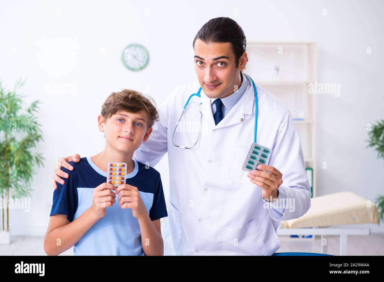 The young male doctor examining boy in the clinic Stock Photo - Alamy