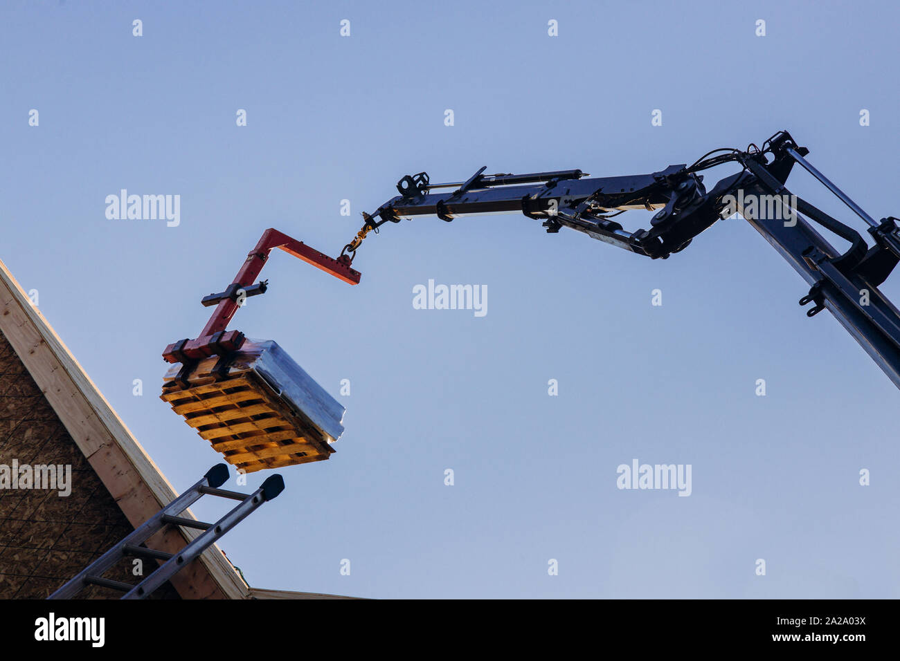 Crane lifting materials roofing material lifted by crane construction ...