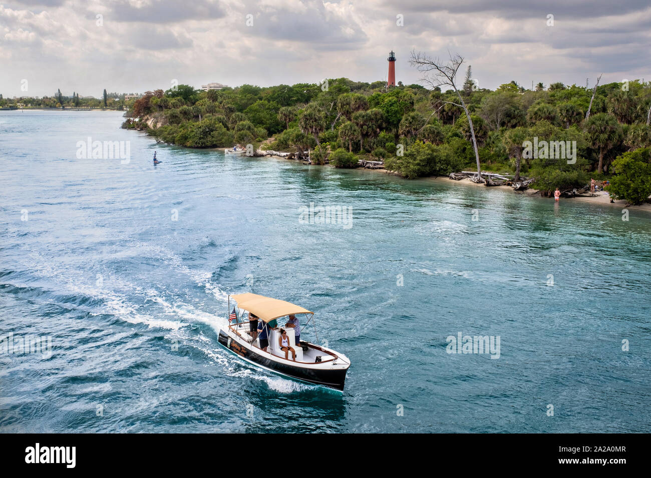 Boats travel along the Indian River past the Jupiter Inlet Lighthouse ...