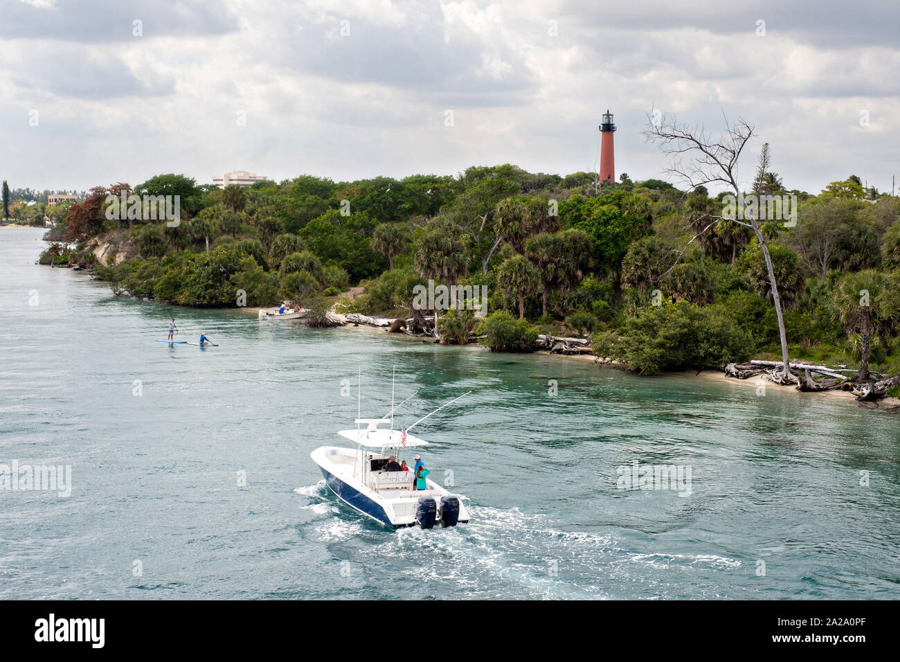 Boats travel along the Indian River past the Jupiter Inlet Lighthouse ...