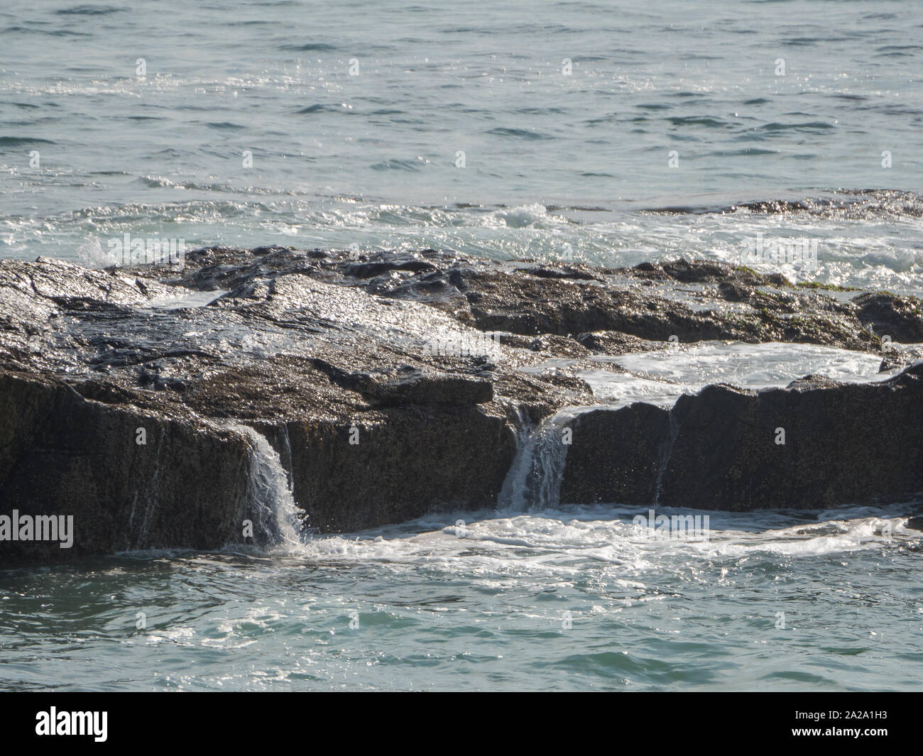 salt water cascading over rocks after a wave Stock Photo - Alamy