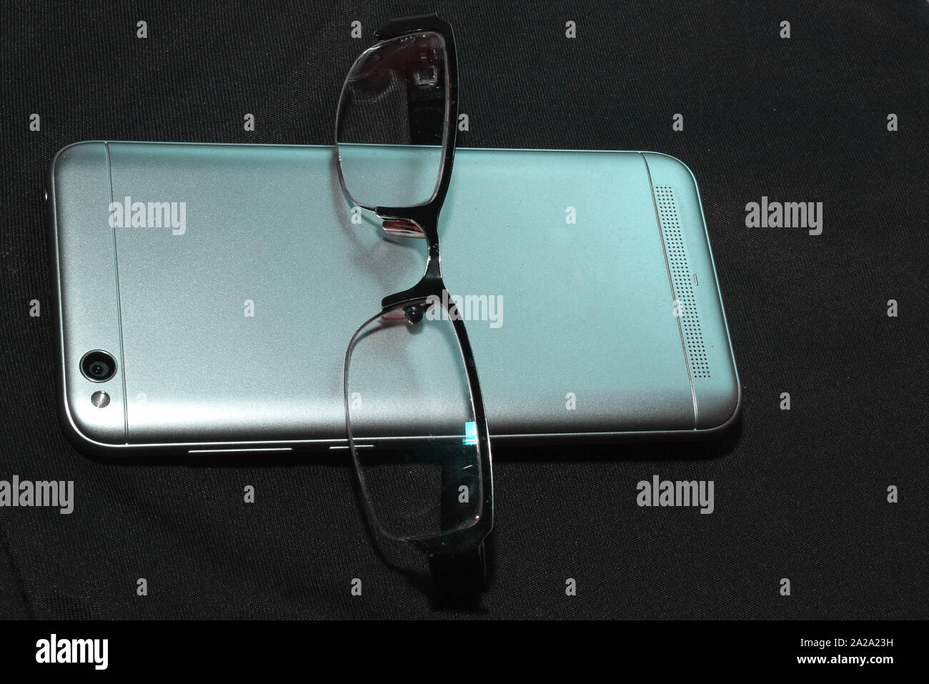 Flat lay photo of black cloth with smart phone and eyeglasses Stock ...