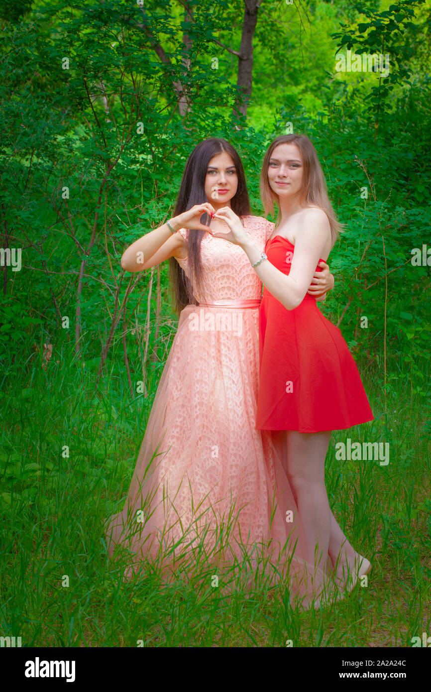 Photos of two beautiful girls in the forest. Woman in beautiful dresses ...