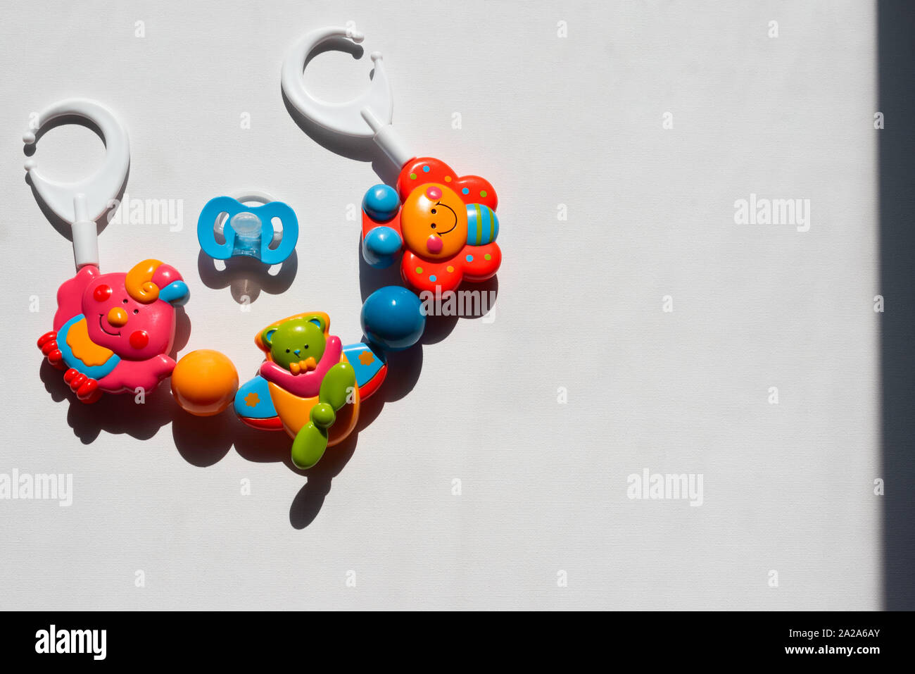Colorful baby rattles on a white background. Contrasting shadows top ...