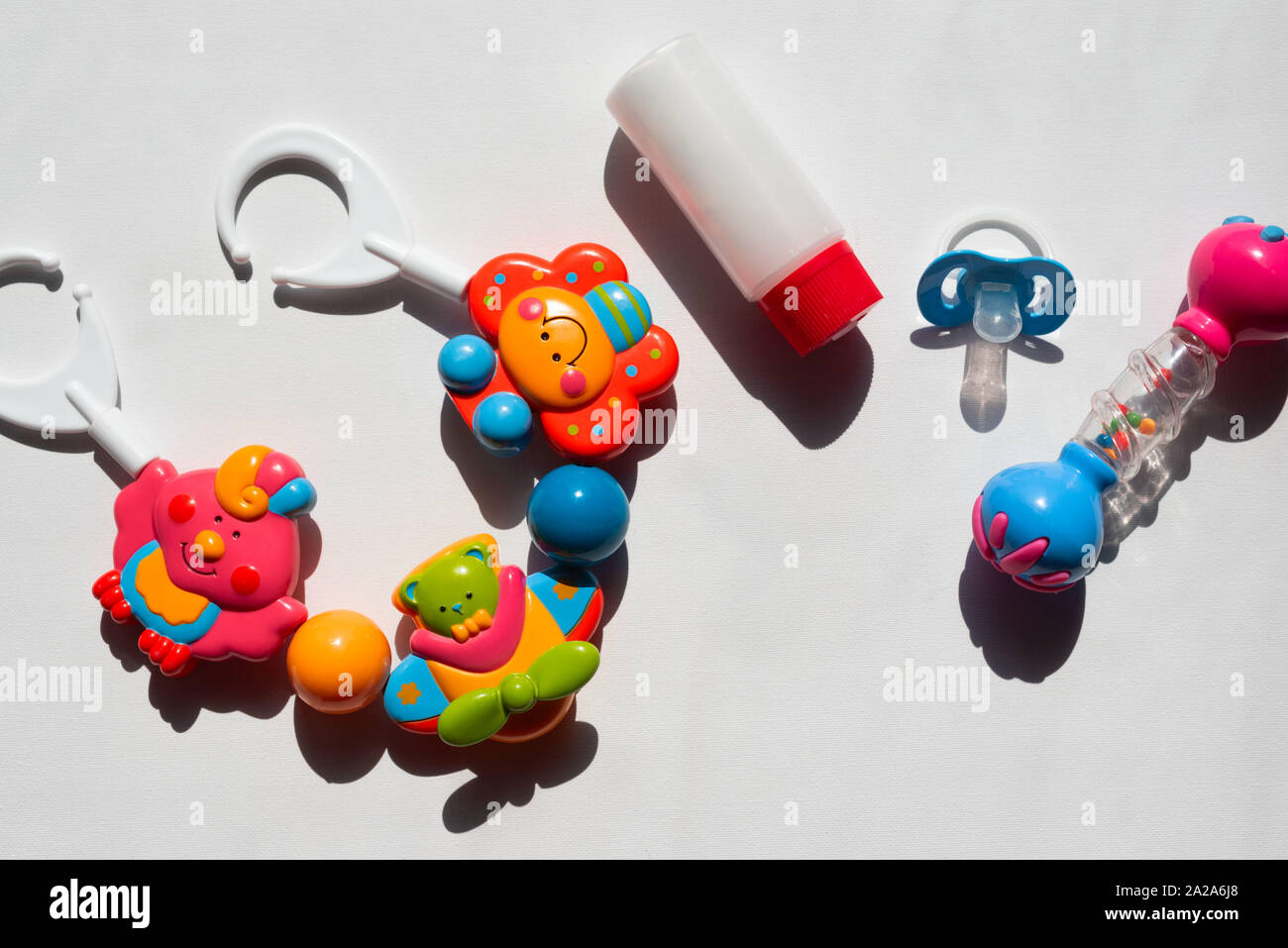 Colorful baby rattles on a white background. Contrasting shadows top ...