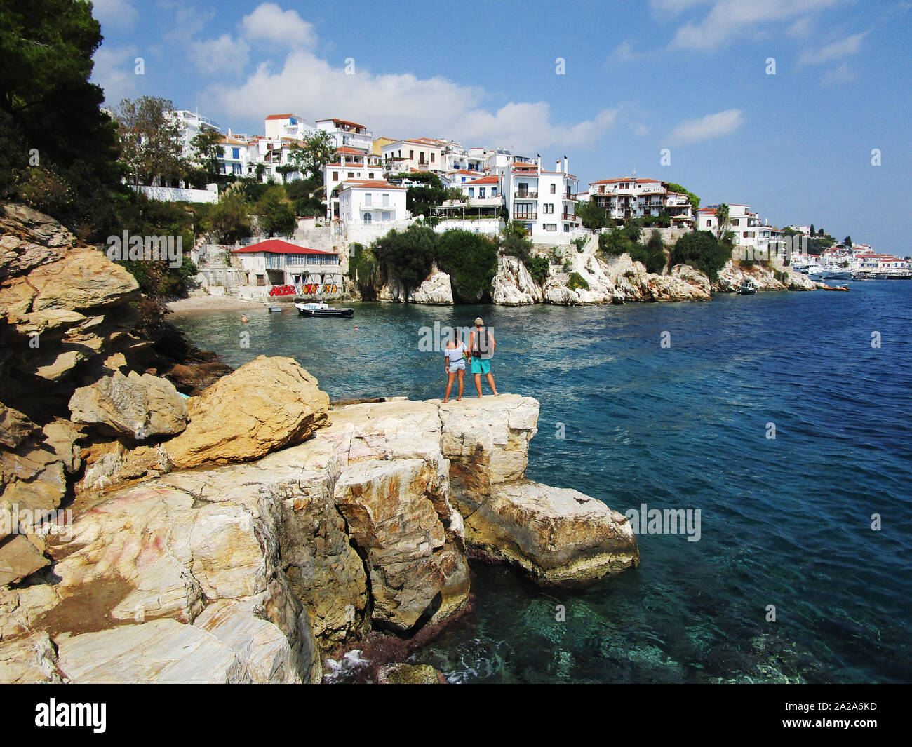 A young couple look at the old town of Skiathos across the bay in ...