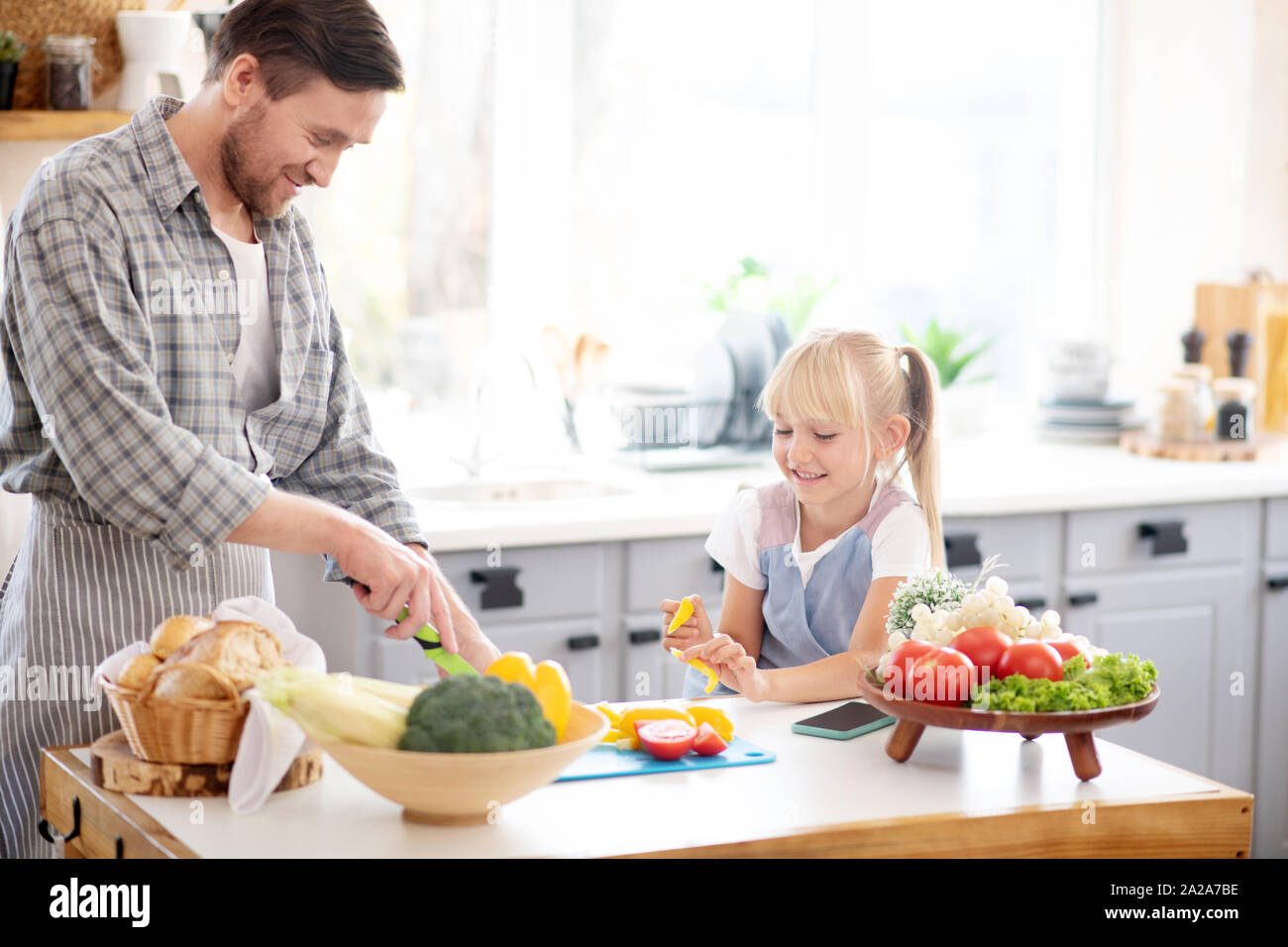 Daughter watching daddy cooking lunch for family Stock Photo - Alamy