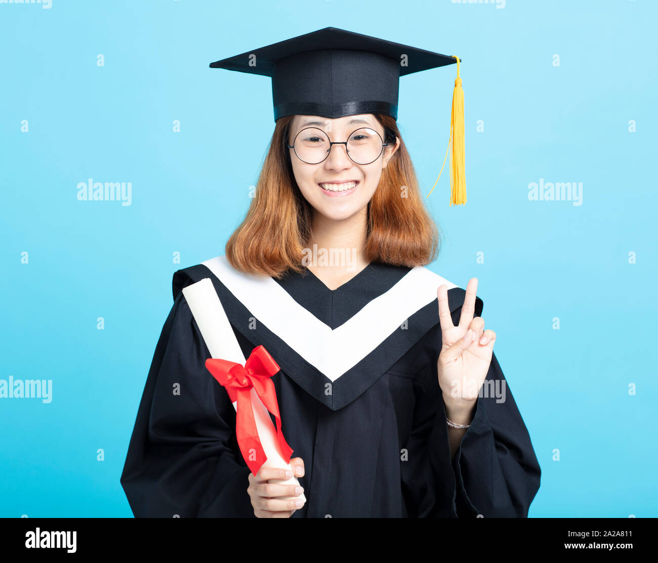 happy success graduation girl with victory gesture Stock Photo - Alamy