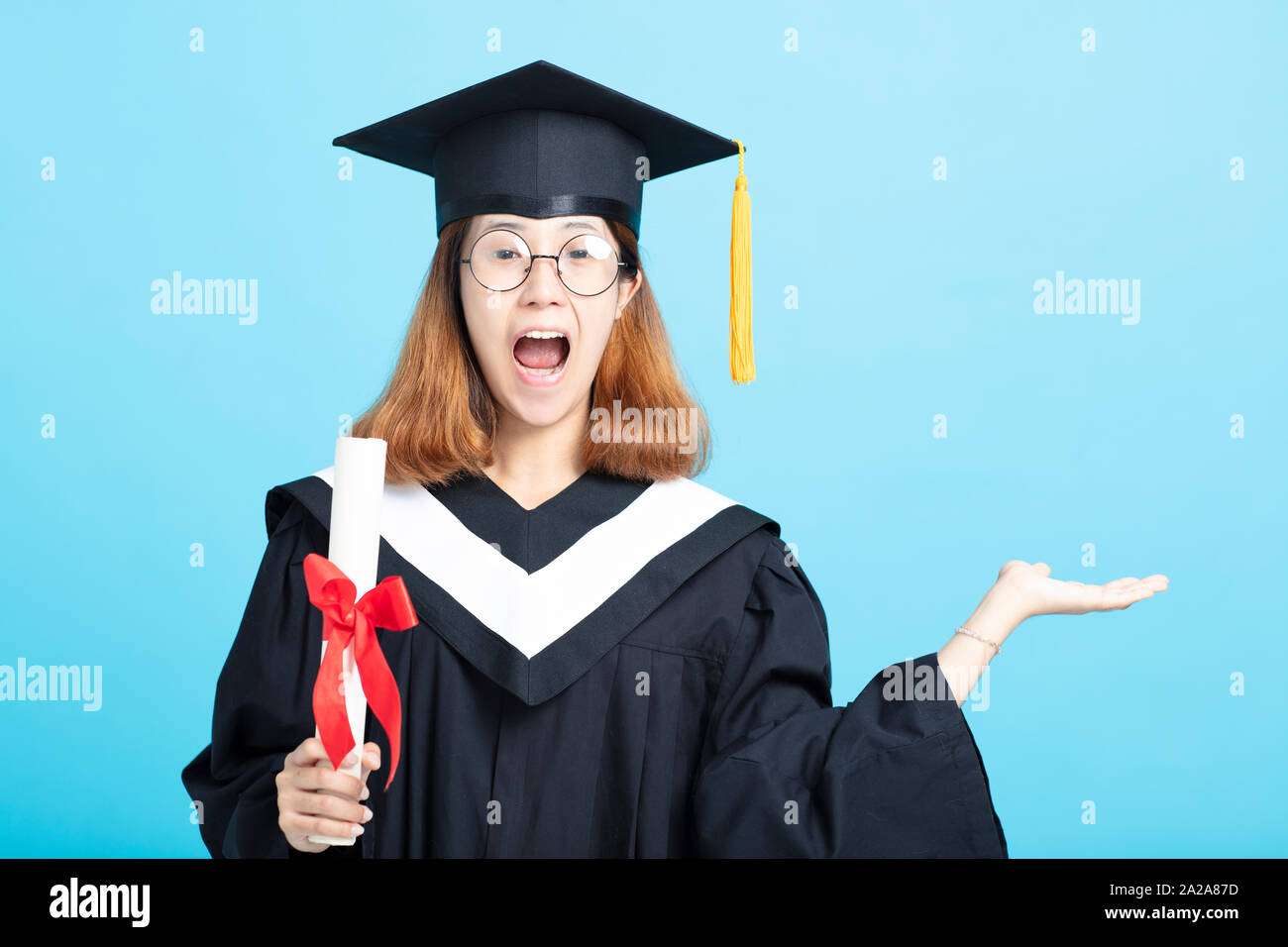 happy and excited graduation girl showing something on hand Stock Photo ...