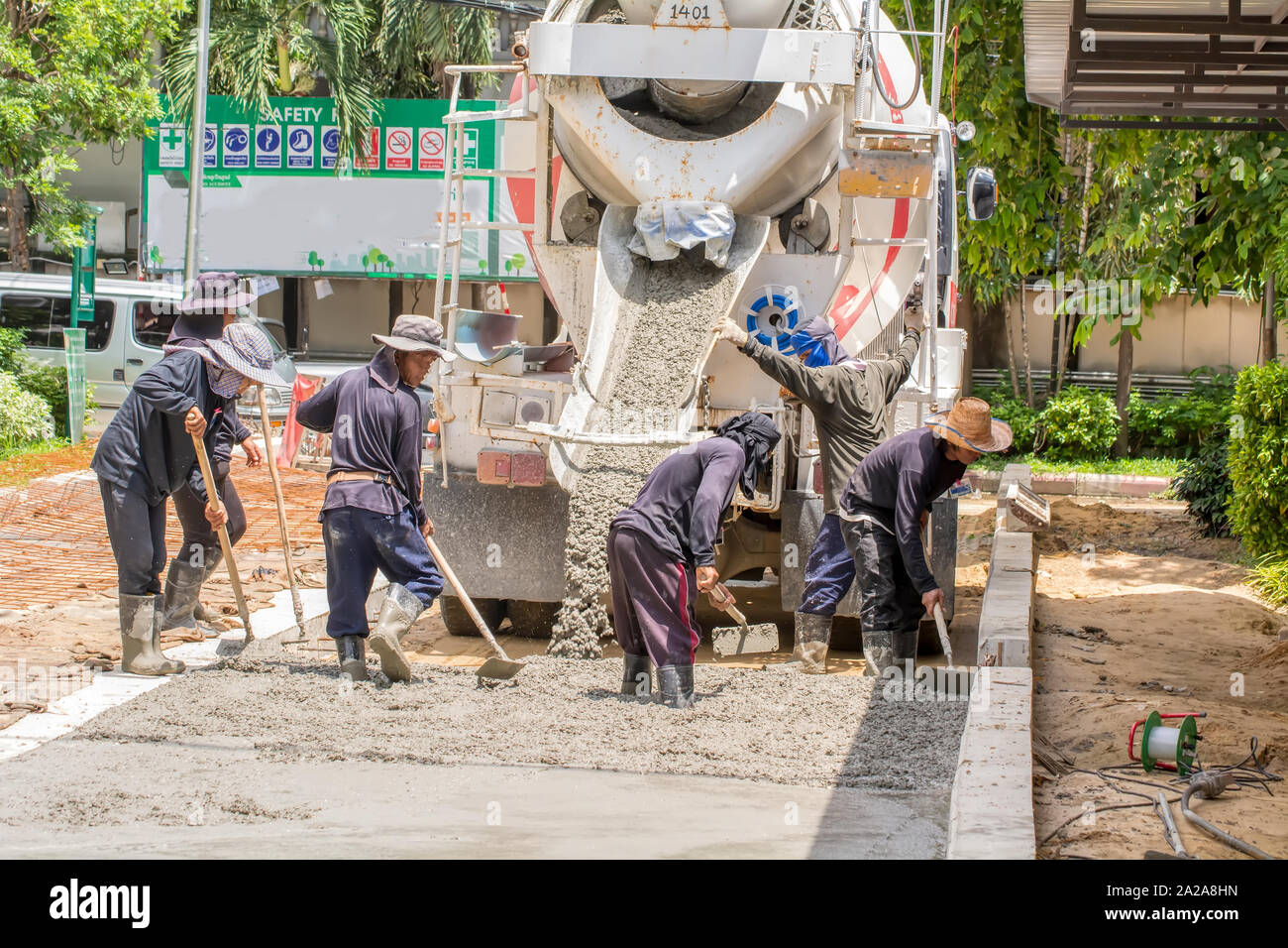 Construction worker pouring cement for doing the road Stock Photo - Alamy