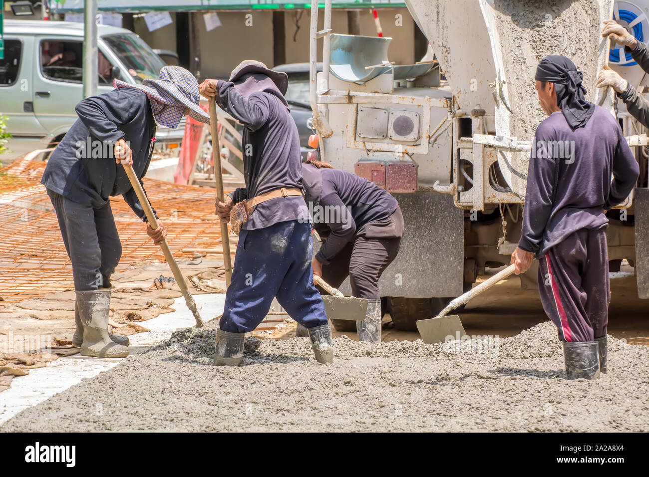 Construction worker pouring cement for doing the road Stock Photo - Alamy