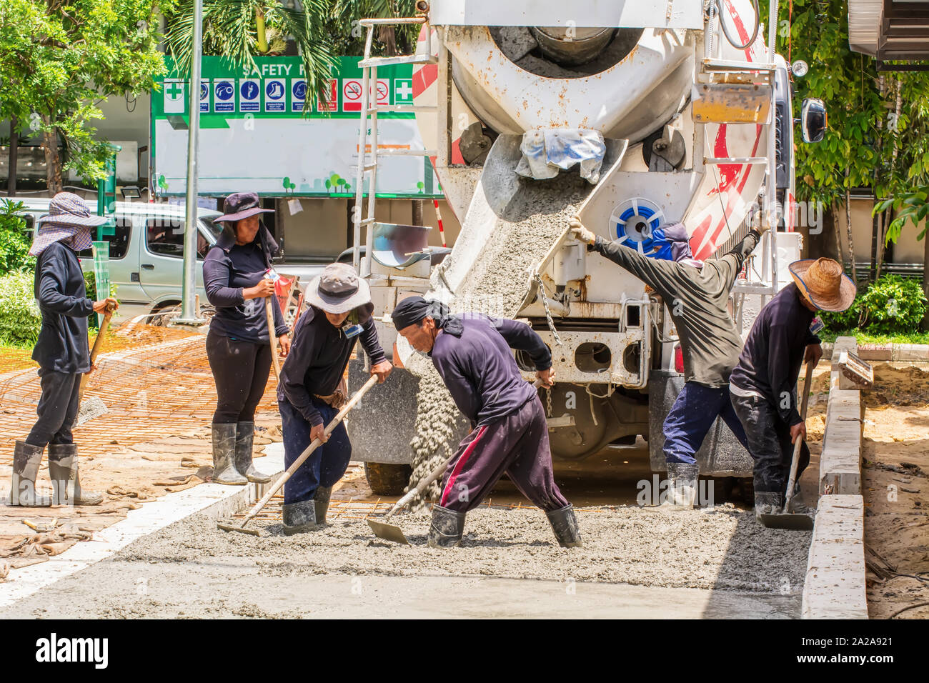 Construction worker pouring cement for doing the road Stock Photo - Alamy