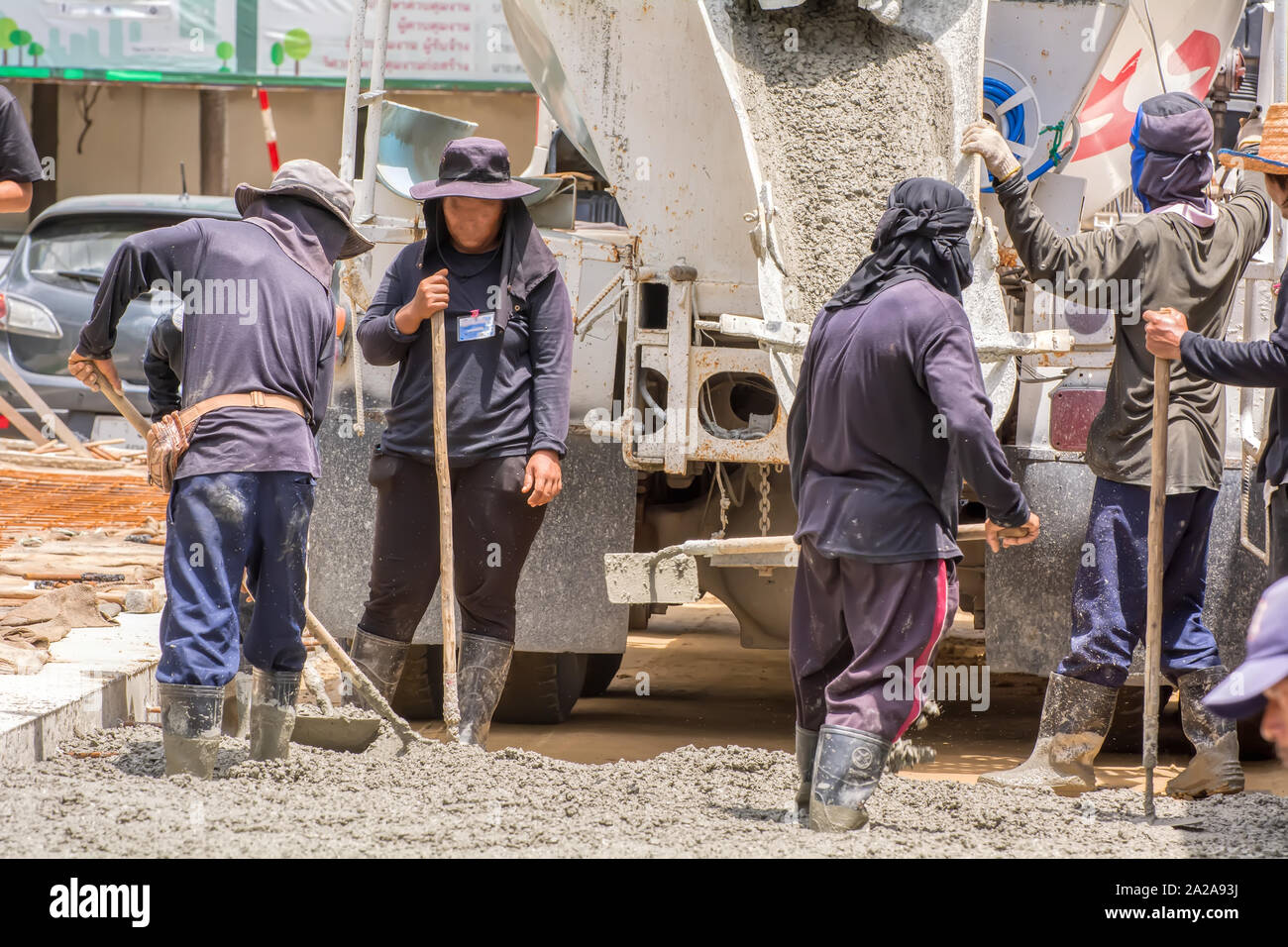 Construction worker pouring cement for doing the road Stock Photo - Alamy