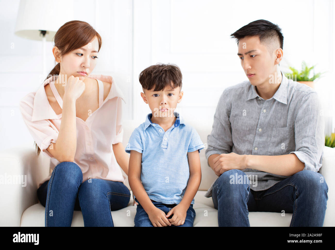 Upset parent and little boy sitting on sofa Stock Photo - Alamy