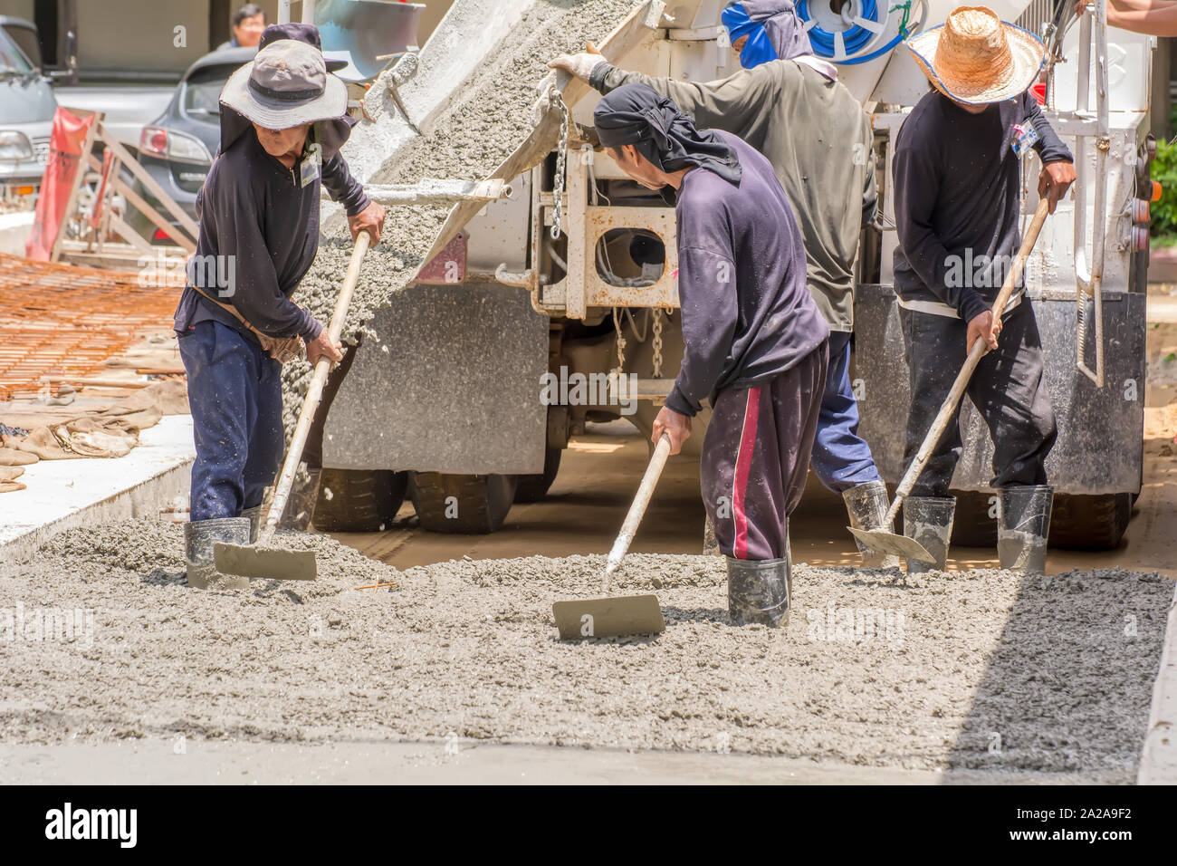 Construction worker pouring cement for doing the road Stock Photo - Alamy
