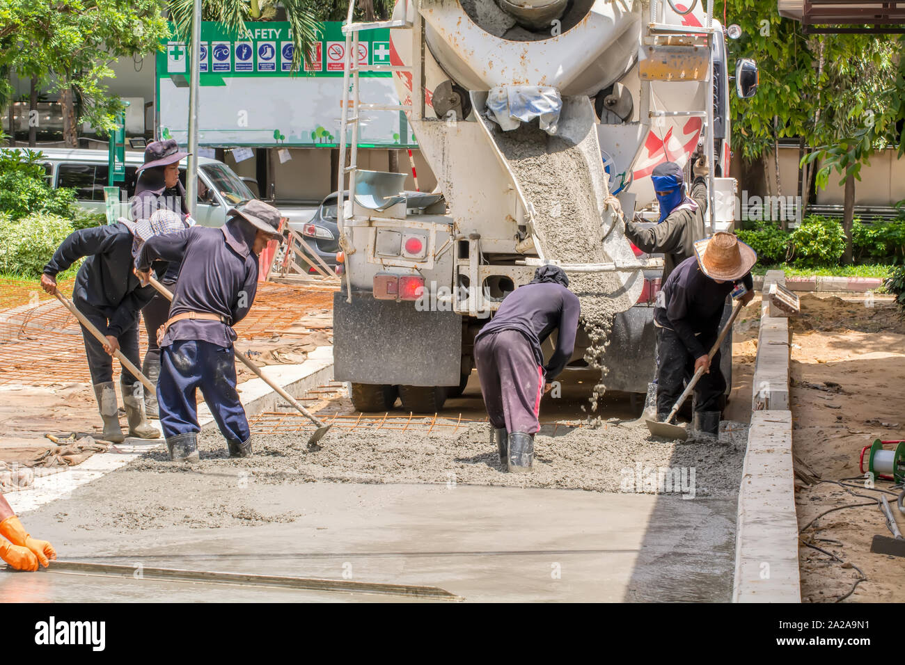 Construction worker pouring cement for doing the road Stock Photo - Alamy
