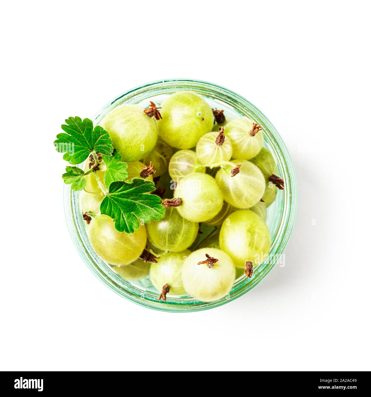 Fresh gooseberry fruits berries with leaves in transparent glass bowl ...