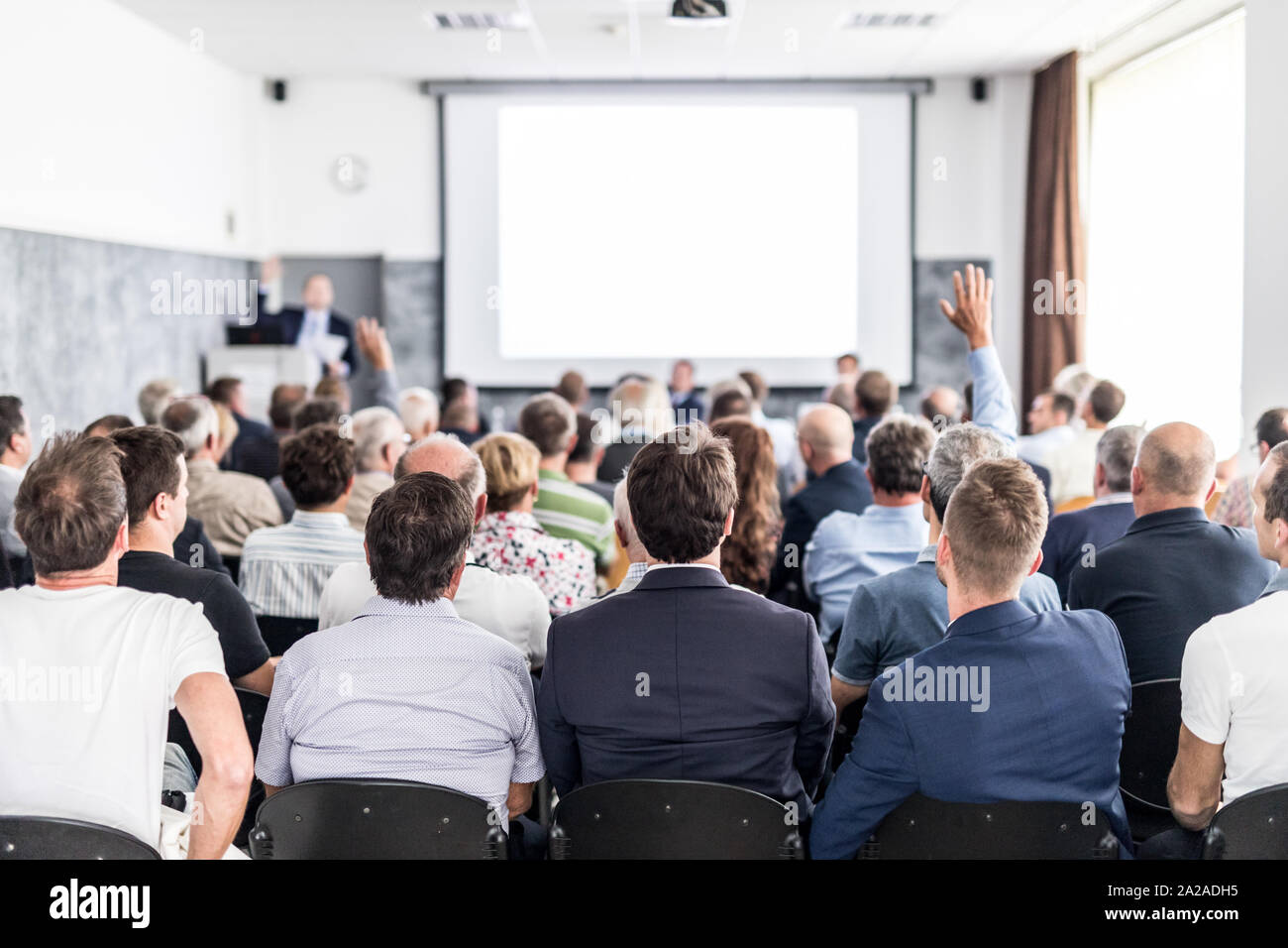 Businesspeople with raised hands voting on resolutions of assembly at ...