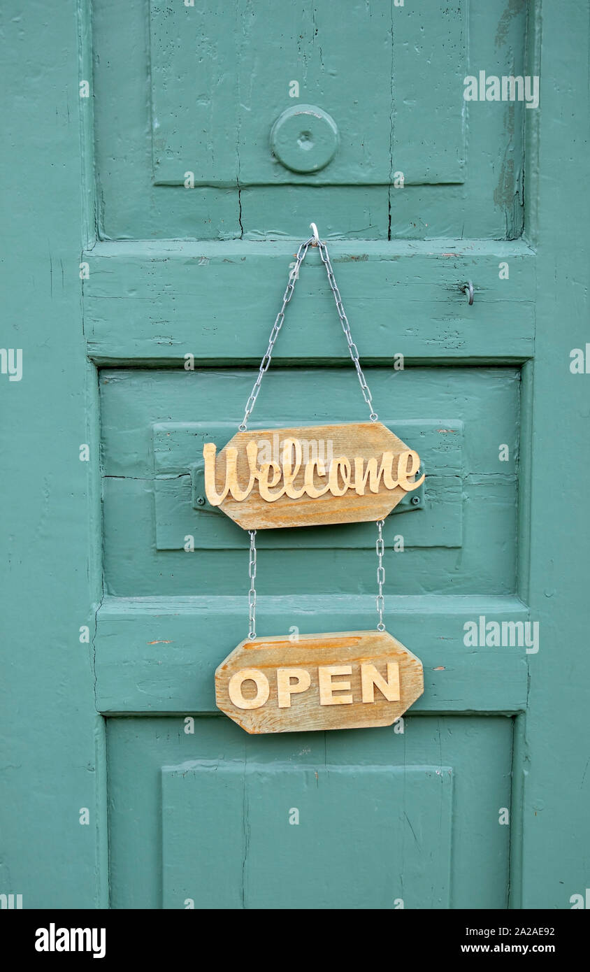 welcome and open signs on green wooden door Stock Photo - Alamy