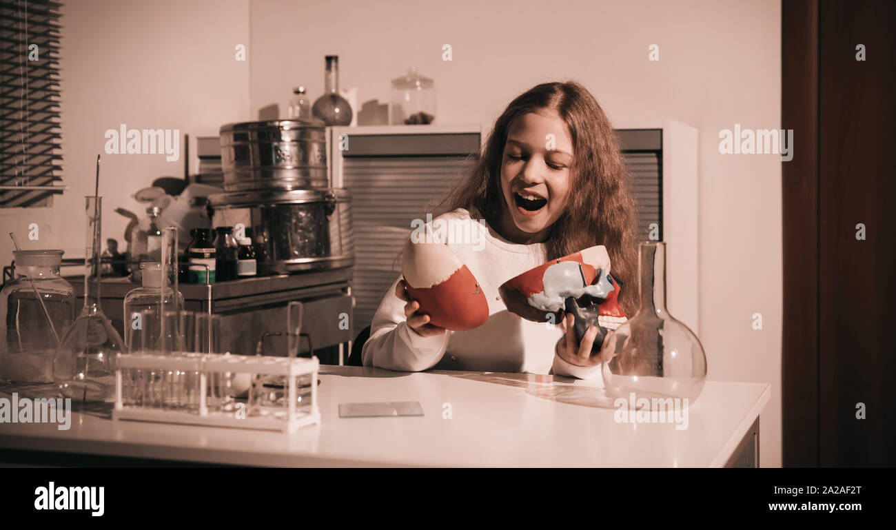 happy schoolgirl girl sitting at a table in her lab Stock Photo - Alamy