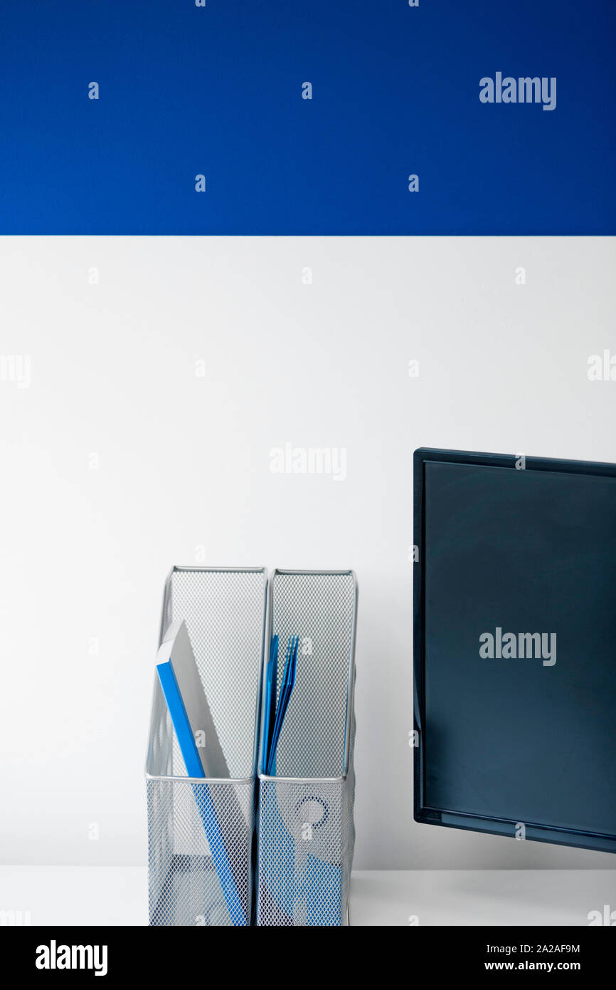 Blue files on a modern office desk with monitor screen Stock Photo - Alamy