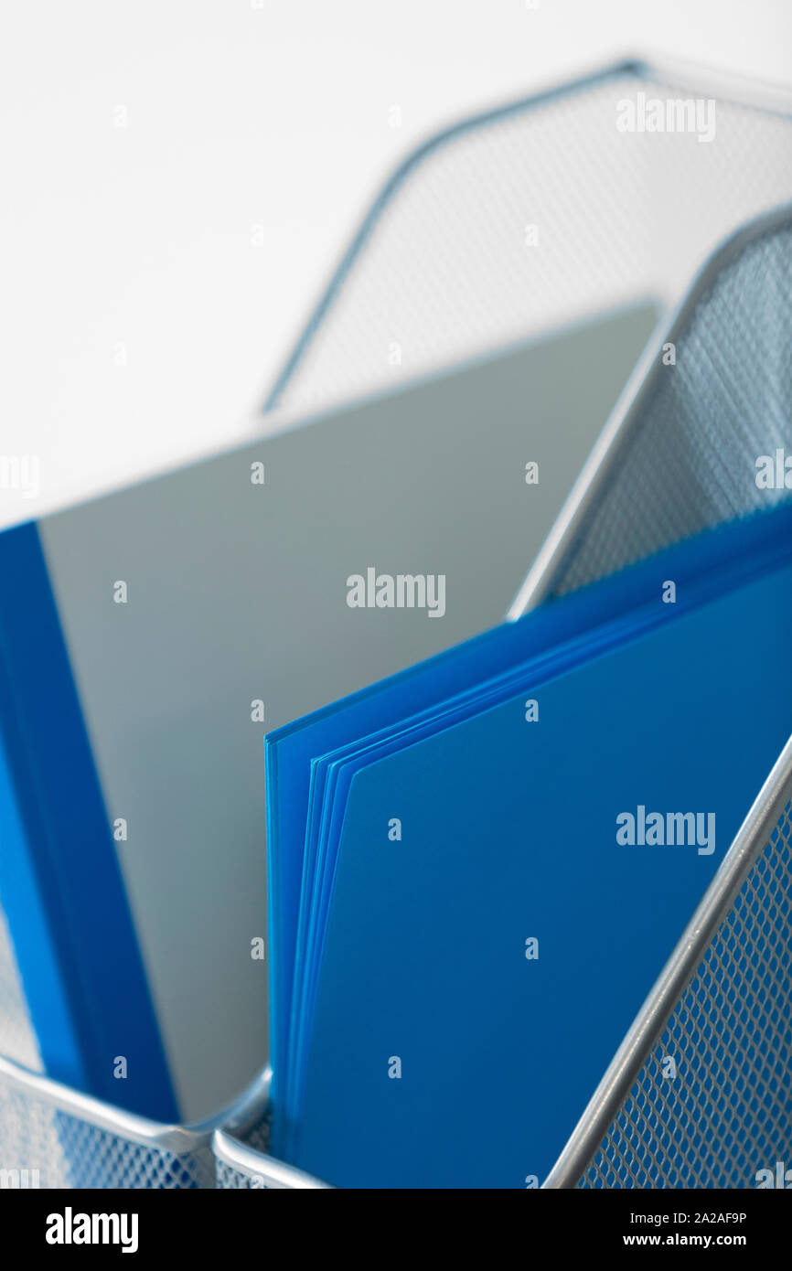 Blue files neatly stacked in metal holder Stock Photo - Alamy