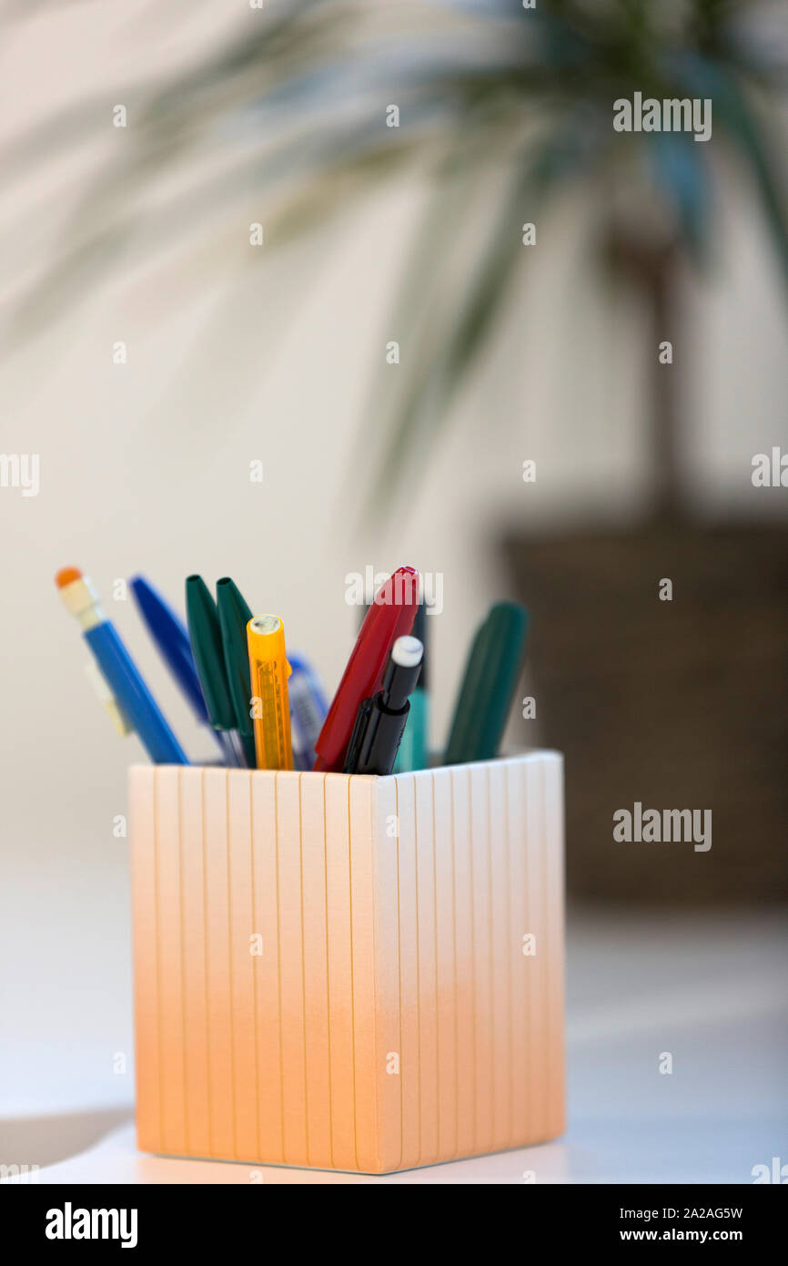 Selection of pens in a pencil pot tidy on a desk Stock Photo - Alamy