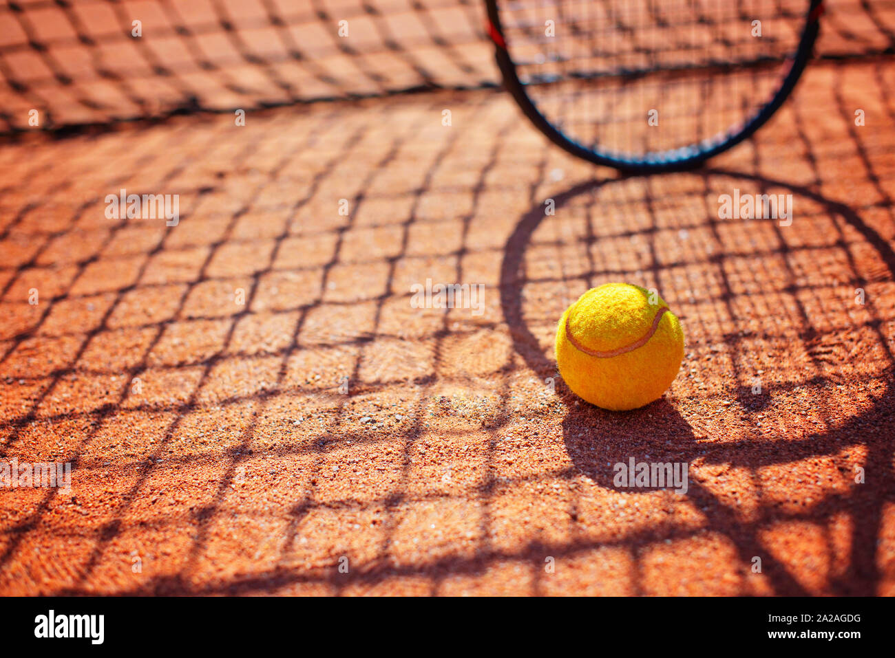 Tennis racket balls laying on the ground in the shadow of the net Stock ...