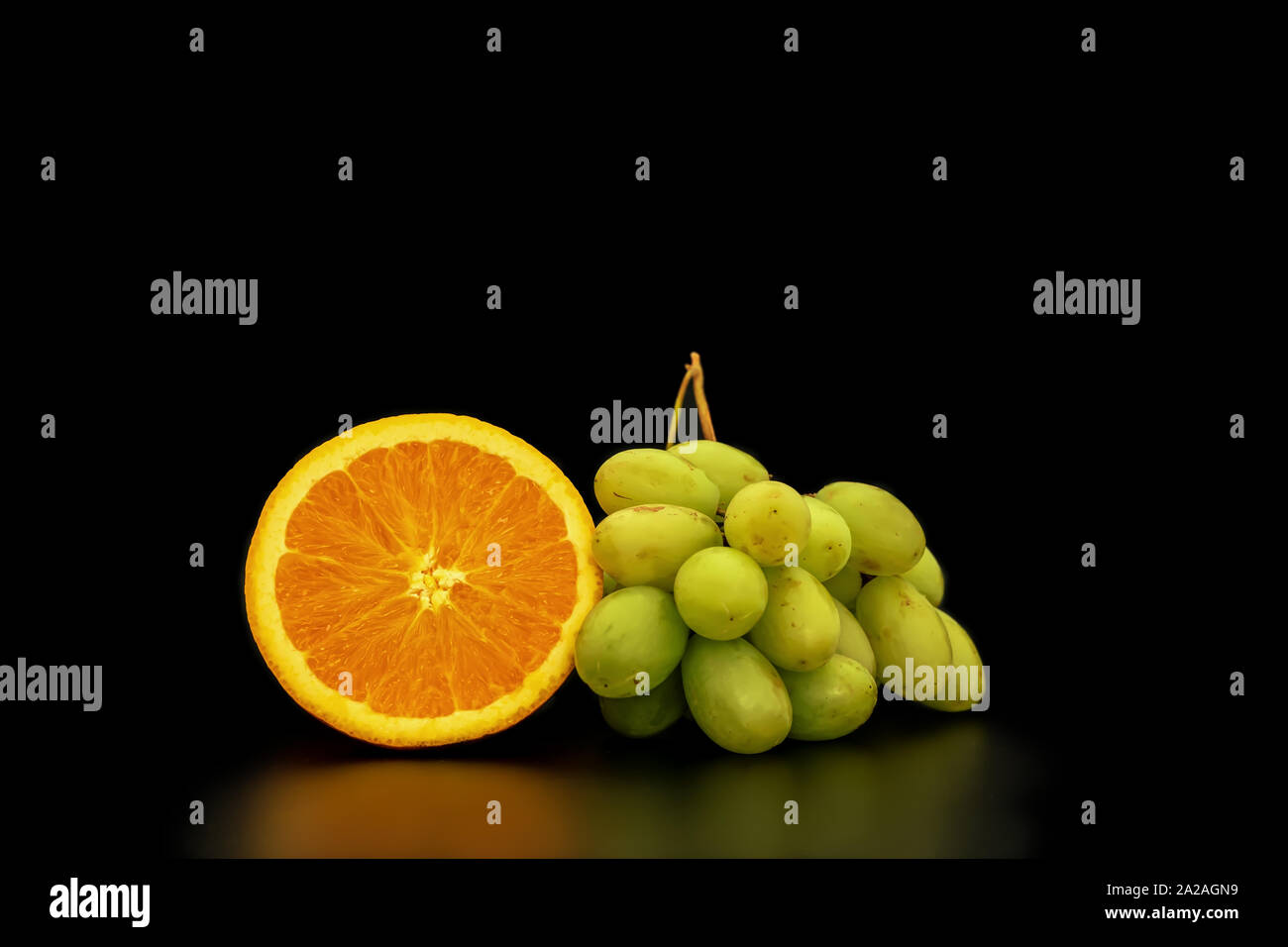 Orange and grapes on a black background Stock Photo - Alamy
