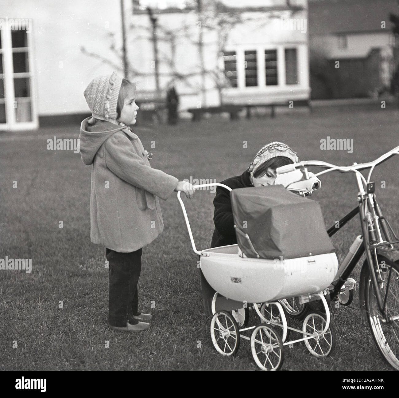 1960s, historical, two young girls outside in a large garden, one with ...