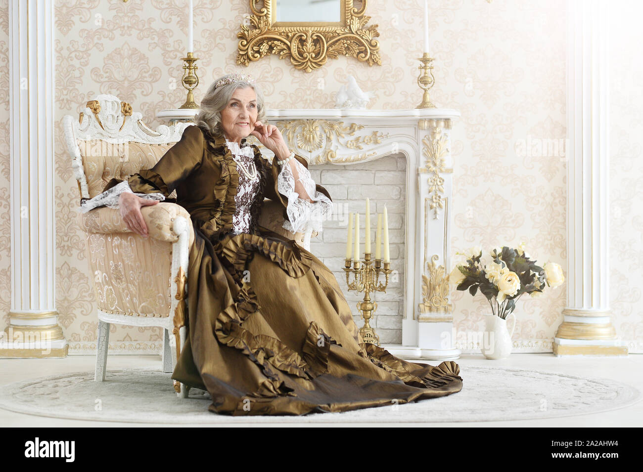 Beautiful senior woman Queen sitting in armchair Stock Photo - Alamy