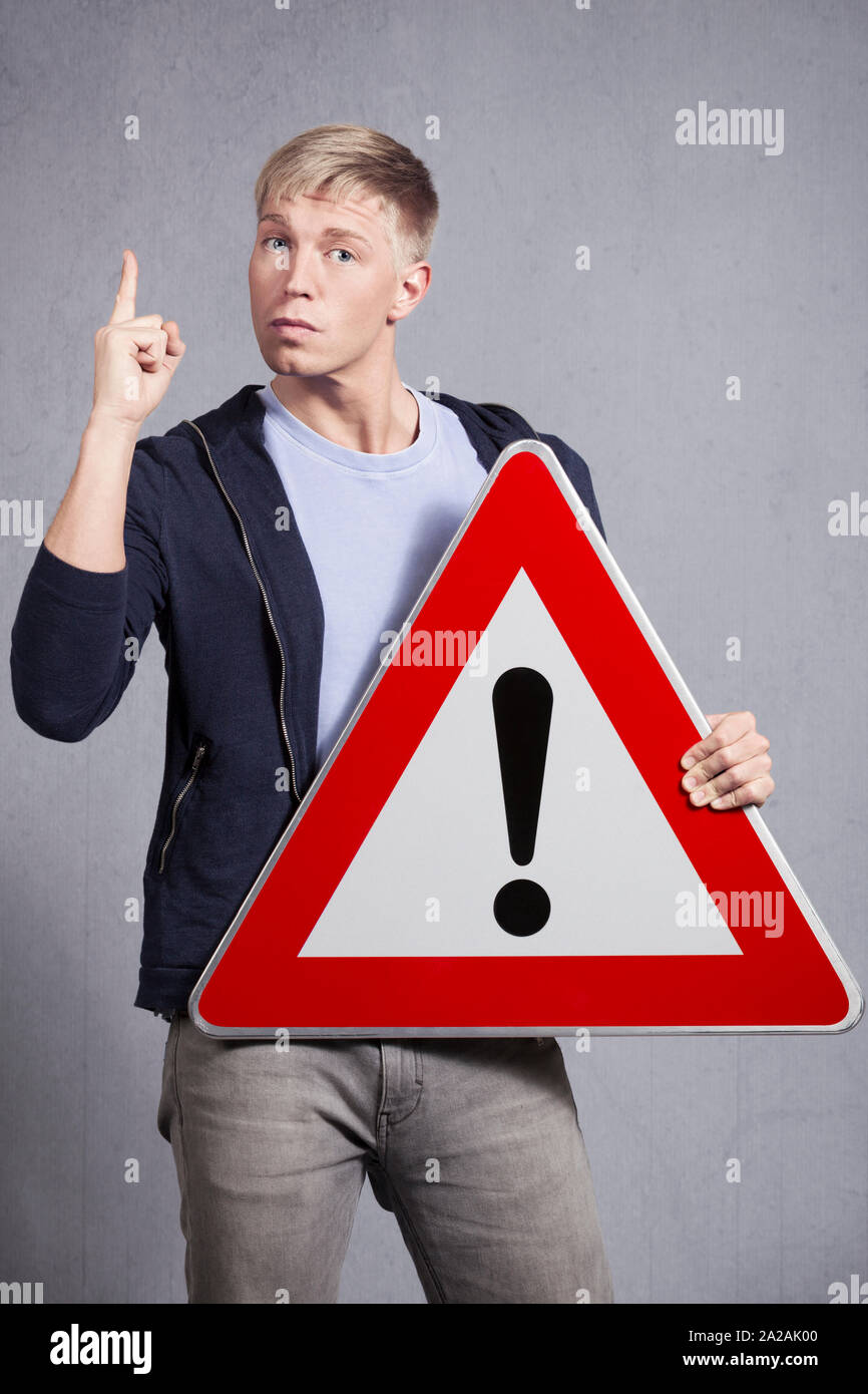Man holding warning sign with exclamation mark Stock Photo - Alamy