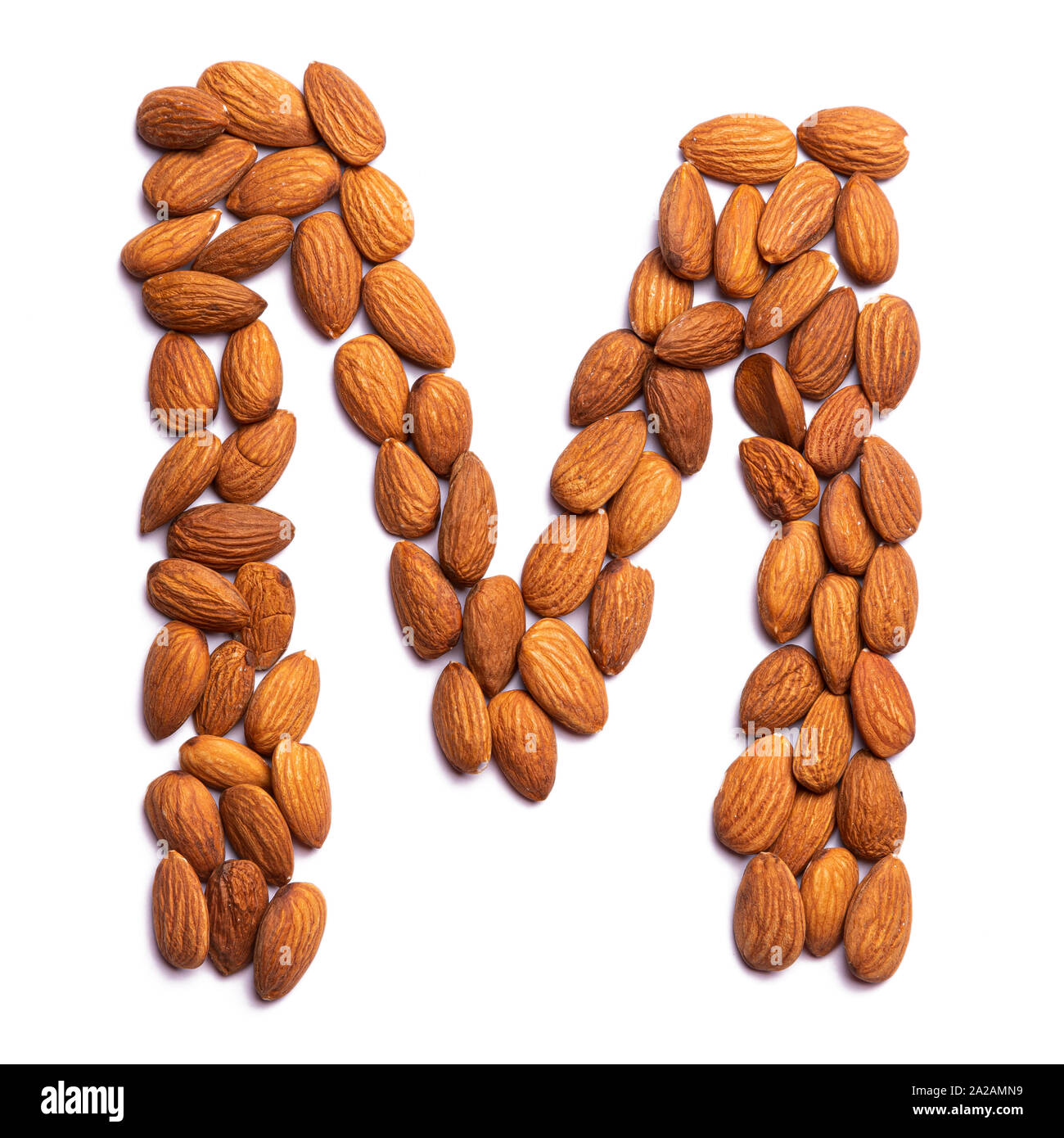 The letter "M" of the English alphabet from a peeled almond on a white ...