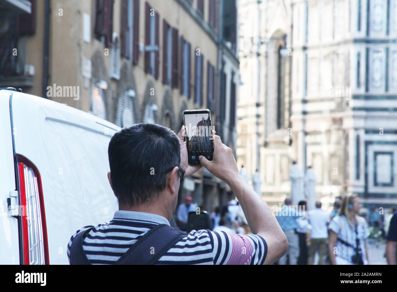 A photograph of a tourist shooting a building with his smartphone, main ...