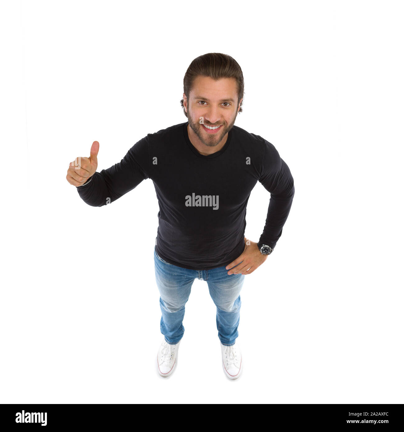 High angle view of young smiling man standing, looking at camera and ...