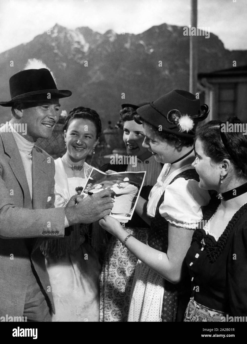 The Australian-American actor Errol Flynn signs a photo for a young ...