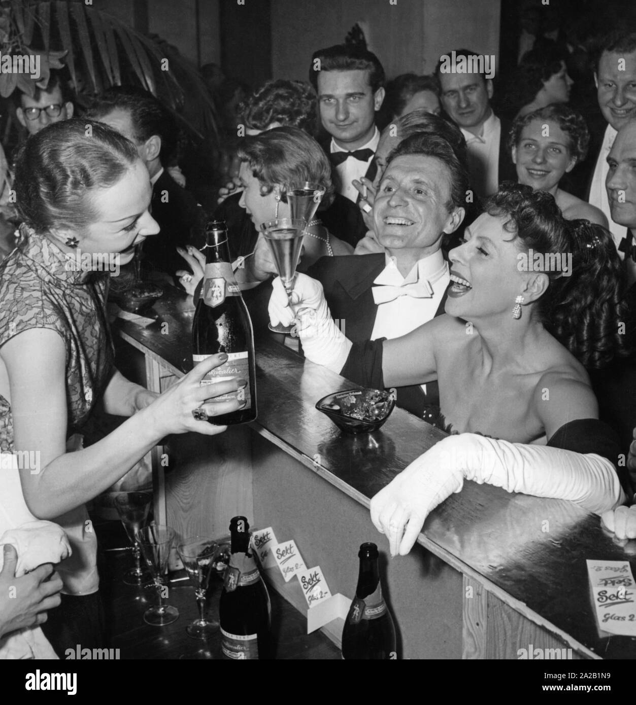 High society at a party in the early 50s, sparkling wine is served at ...