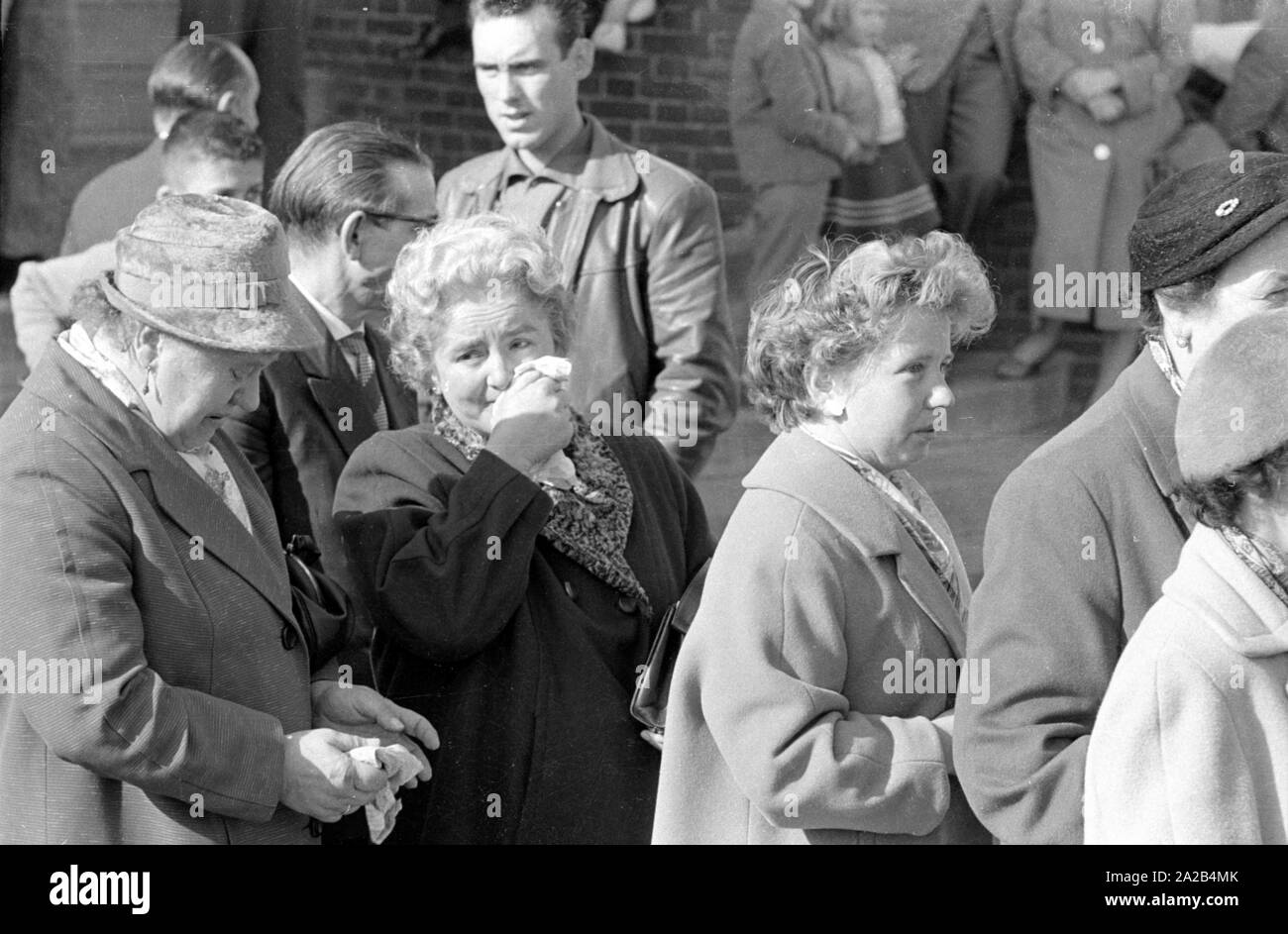 Sad family members and friends say goodbye to a group of young women ...