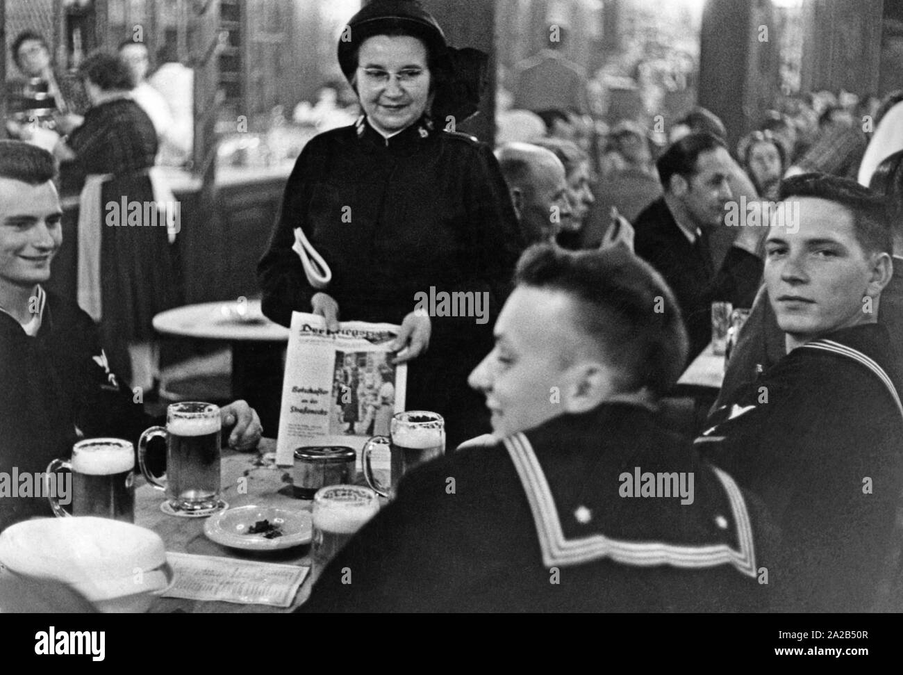 A Salvation Army employee offers a magazine to soldiers. The sailors ...