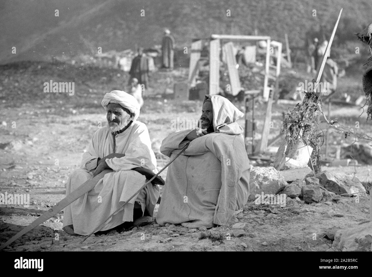 Two men are sitting on the ground. From the report "Earthquake in ...
