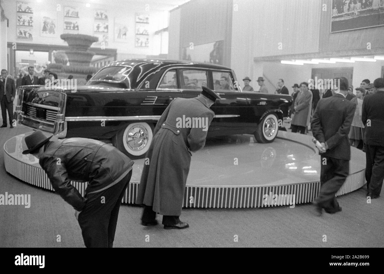 The city during the Spring Fair in 1960. Visitors in front of a car of ...