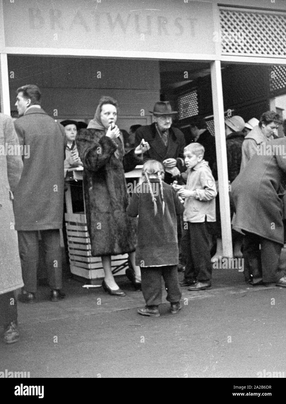 The city during the Spring Fair 1960. People at a sausage stall Stock ...