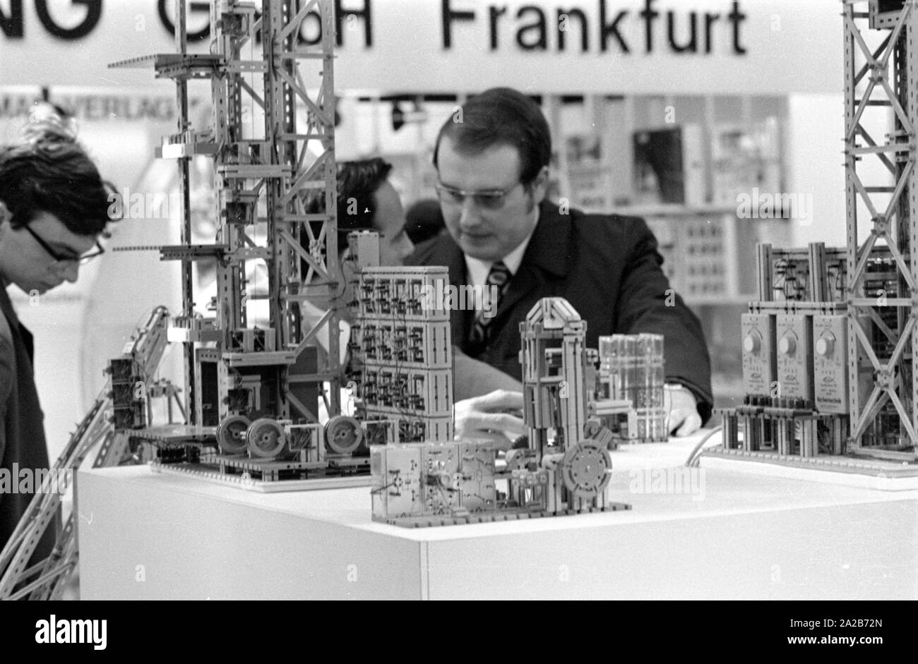 Visitors of the fair look at a construction (possibly metal ...
