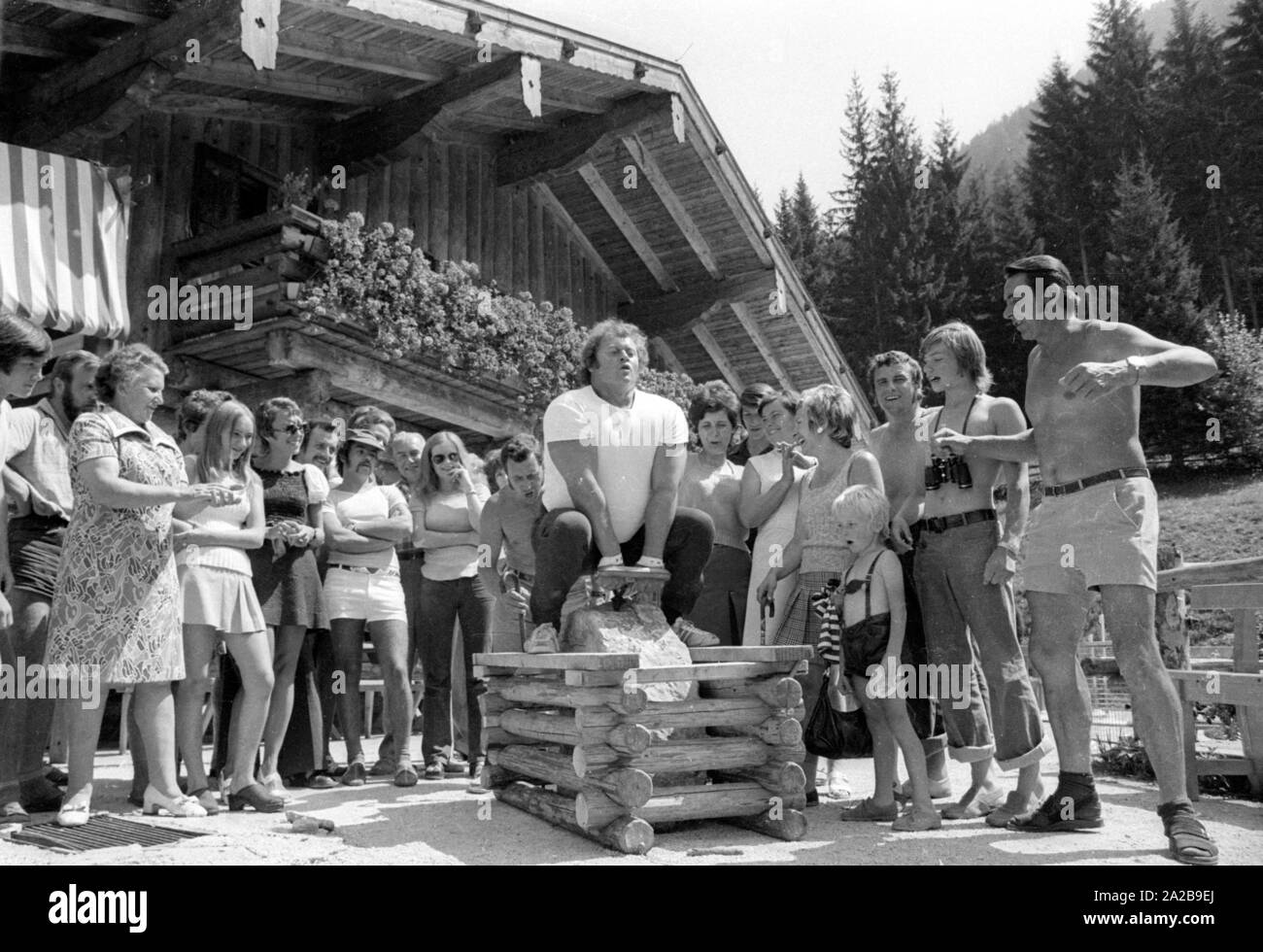 A man demonstrates his strength in stone lifting, a traditional alpine ...