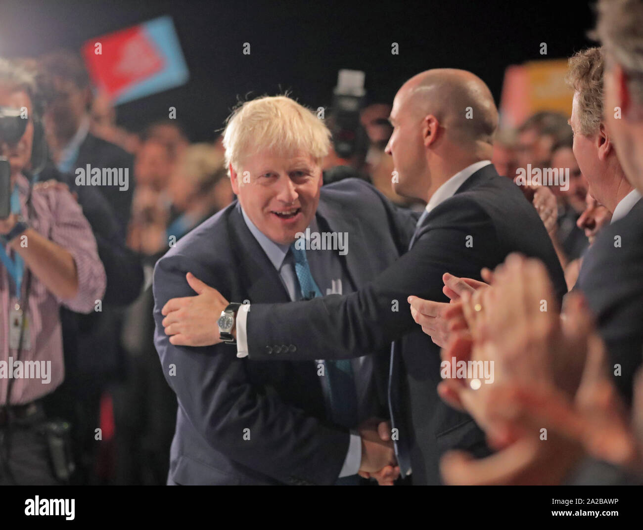 Prime Minister Boris Johnson greets the audience as he makes his way to ...
